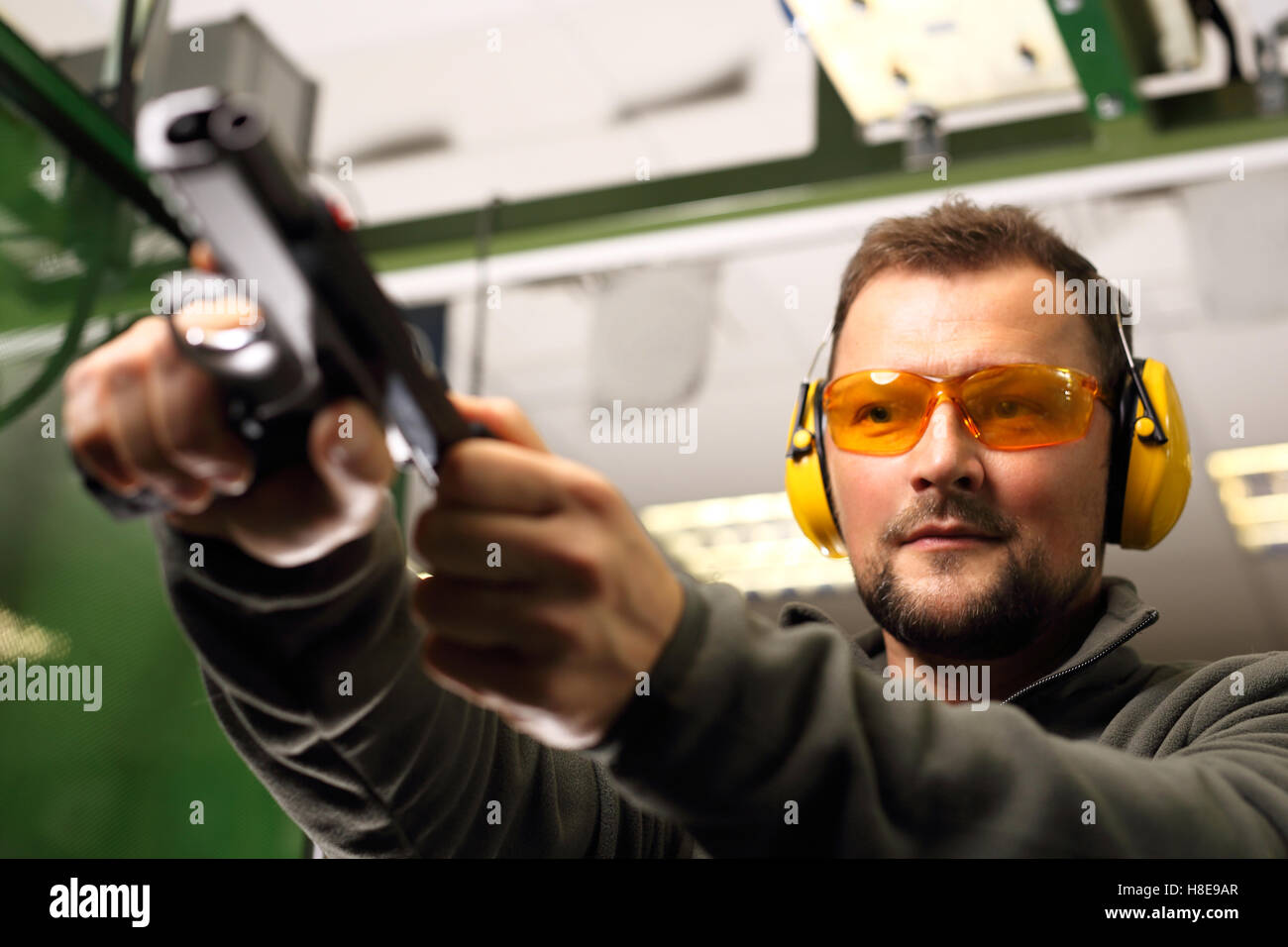 Shooting a gun at a shooting range. The man at the shooting reloads ...