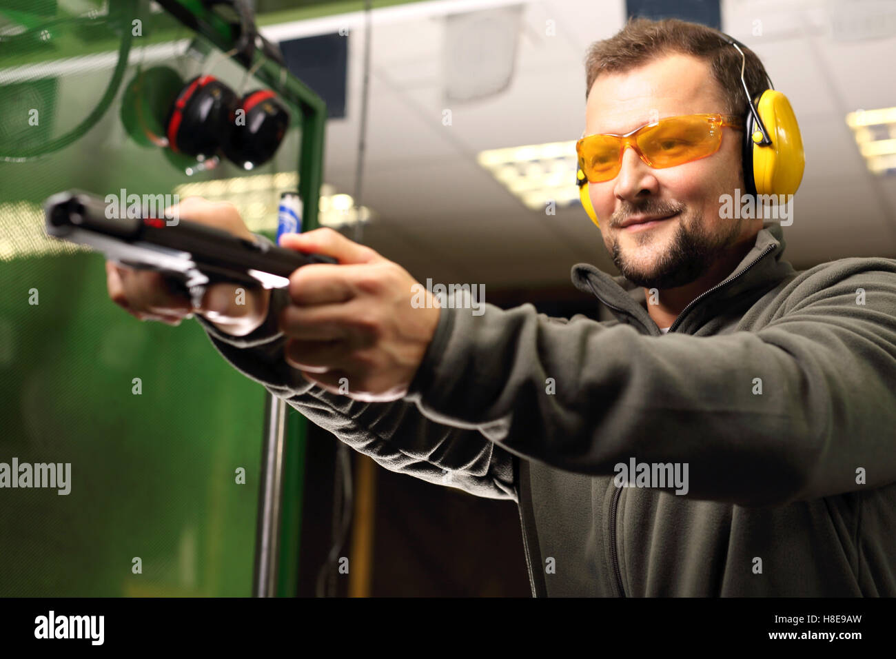 Shooting a gun at a shooting range. The man at the shooting reloads ...