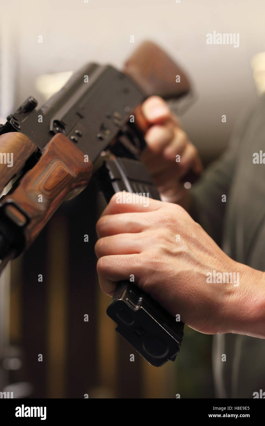 Shooting a gun at a shooting range. The man at the shooting reloads ...