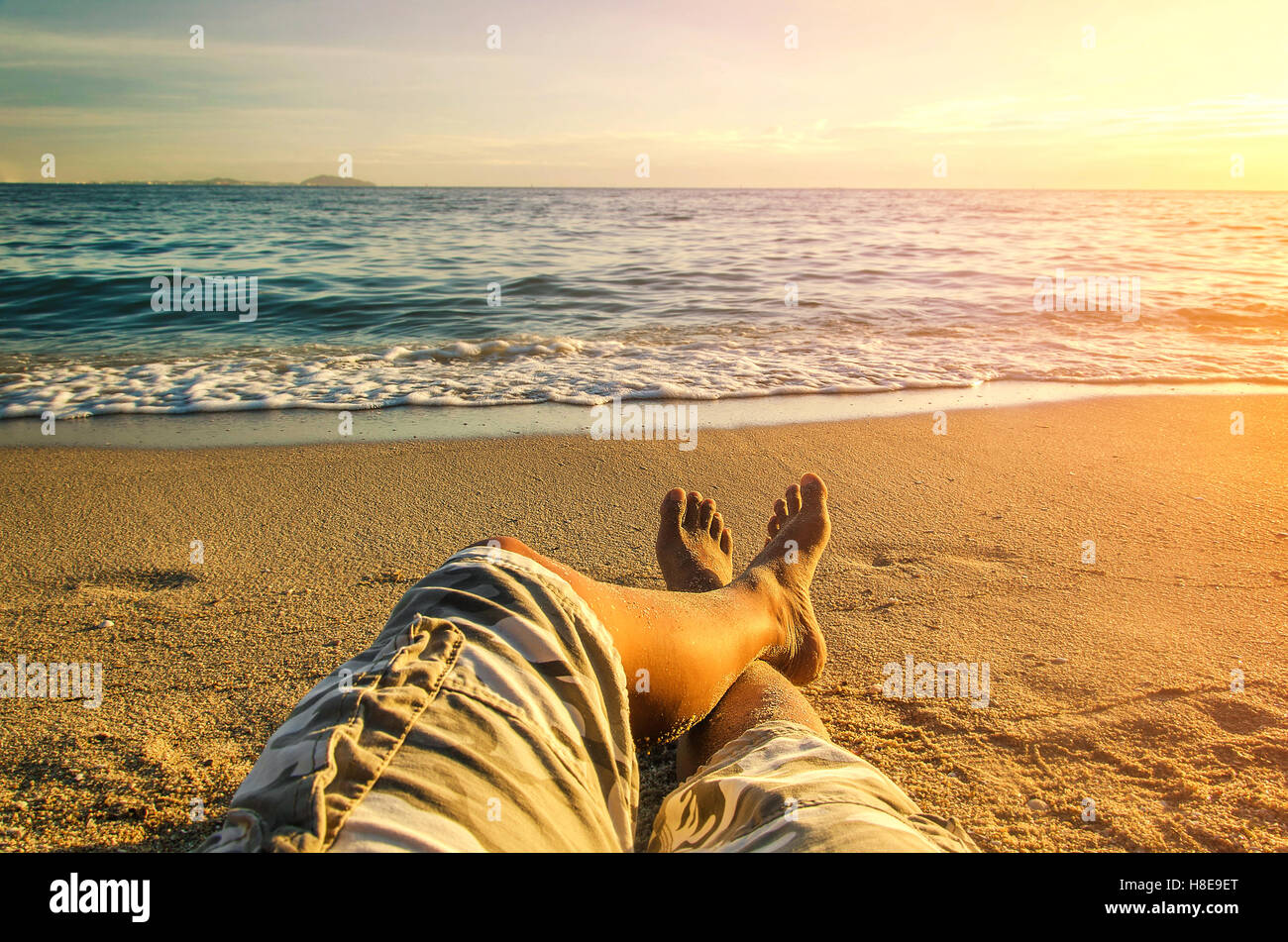Man relaxing on beach, ocean view Stock Photo - Alamy