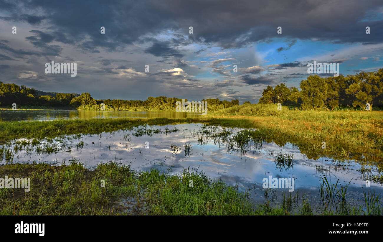 Cloudy sky over beautiful flood plain landscape. River landscape ...