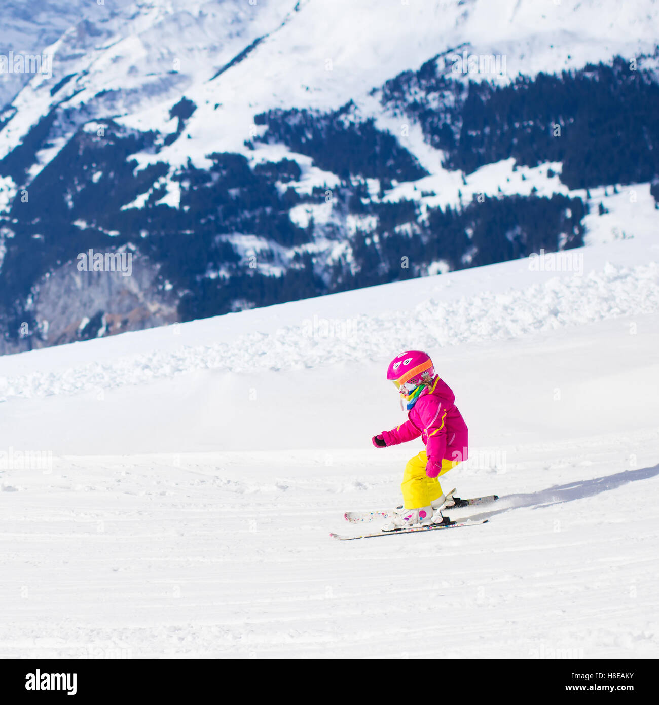 Child skiing in mountains. Active toddler kid with safety helmet ...