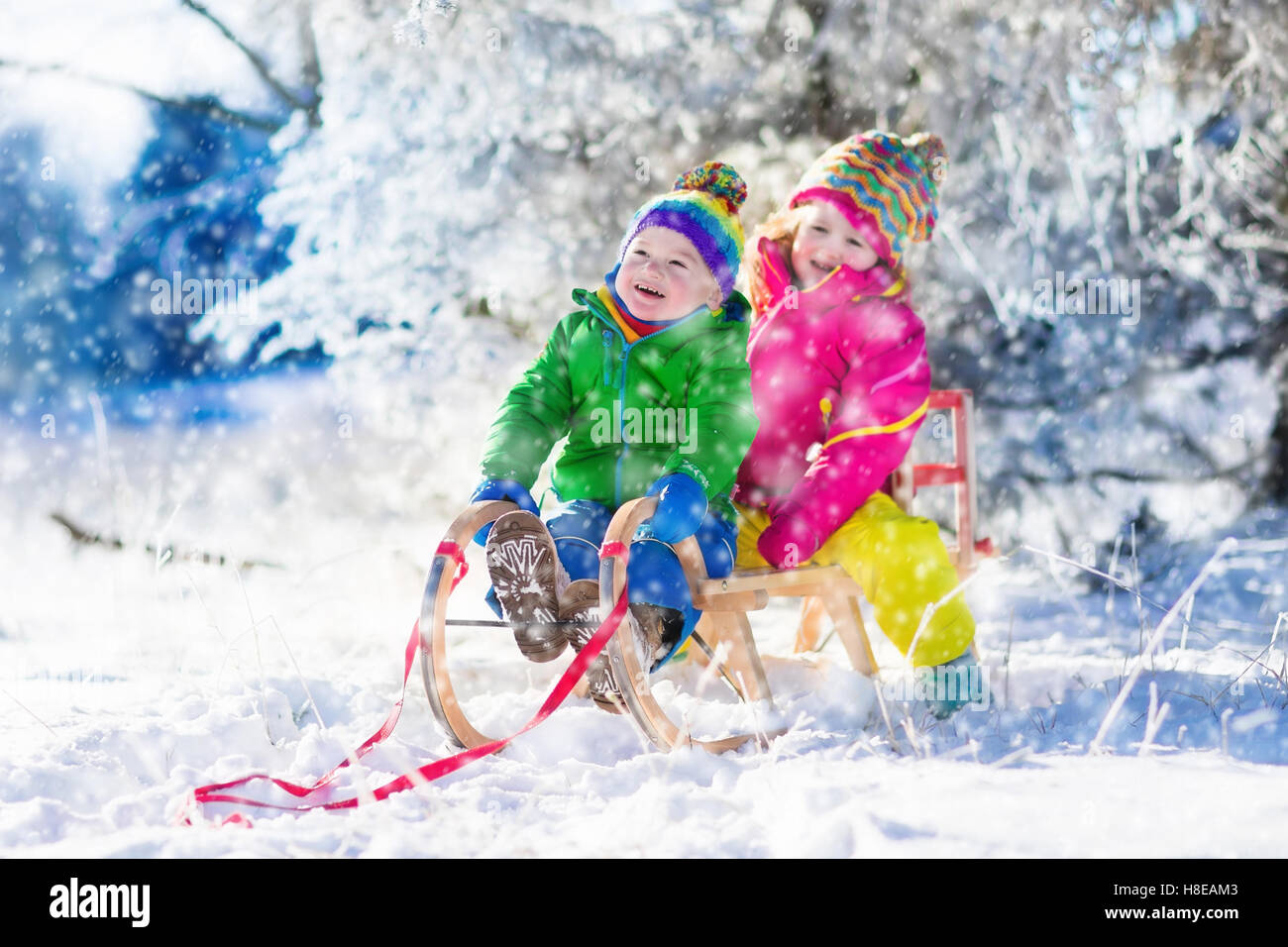 Little girl and boy enjoying sleigh ride. Child sledding. Toddler kid ...