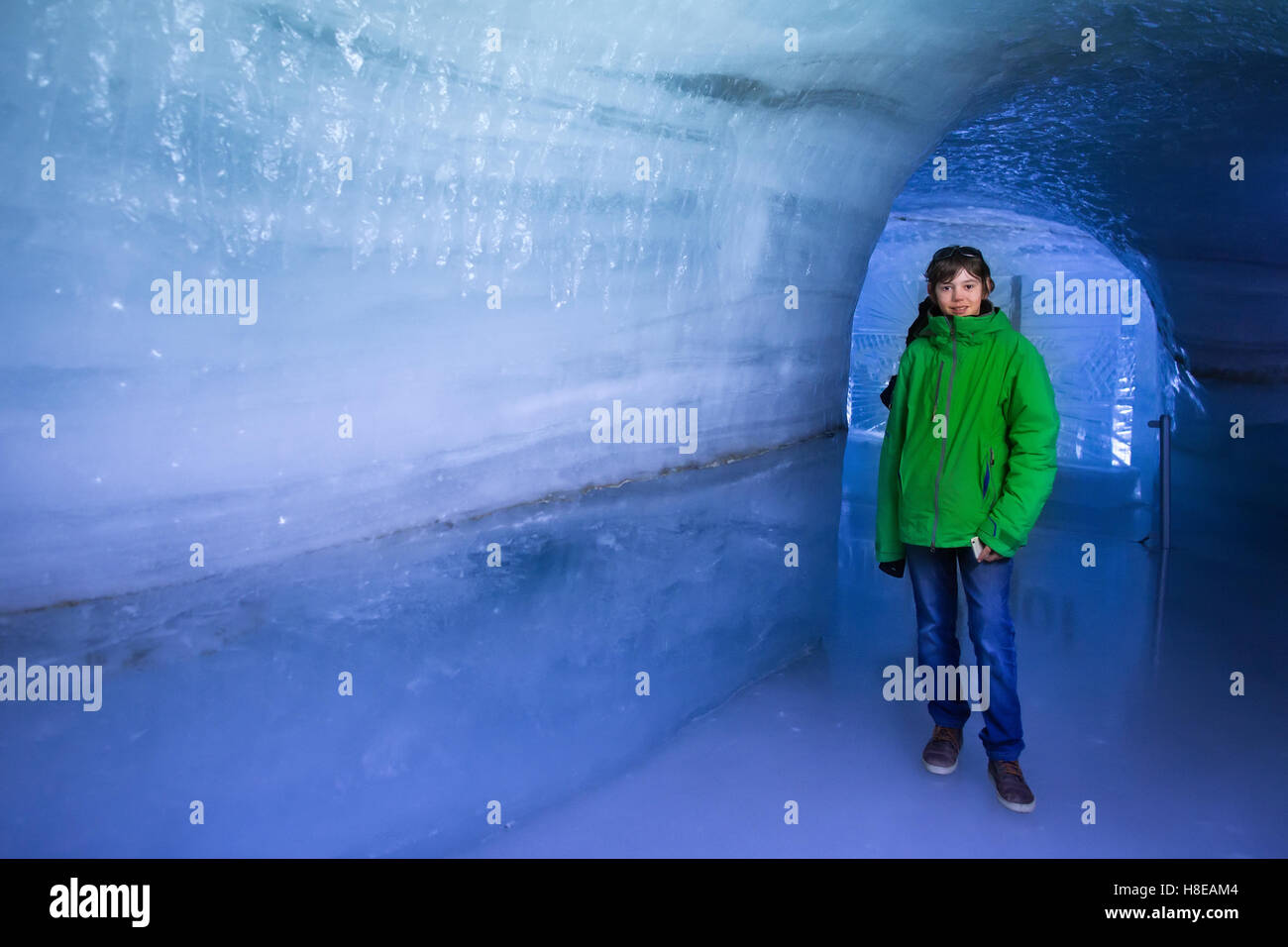 Child visiting ice cave tunnel in Swiss Alps glacier. School kid ...