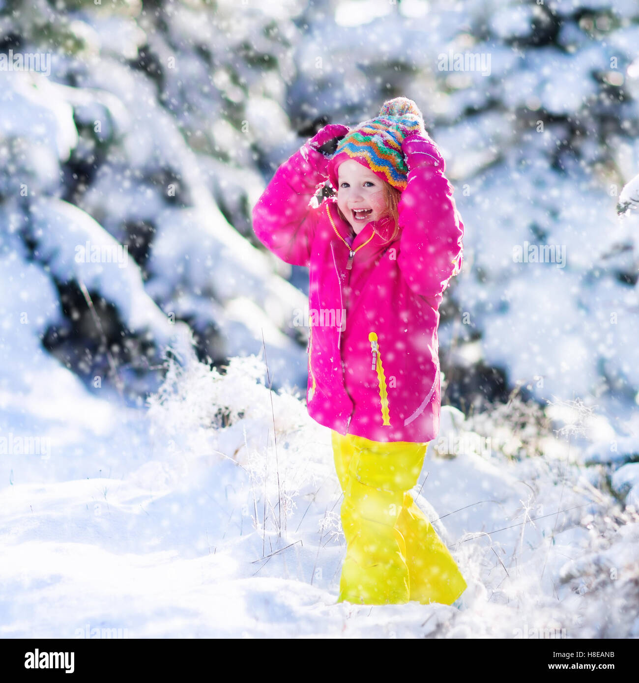 Child running in snowy forest. Toddler kid playing outdoors. Kids play ...