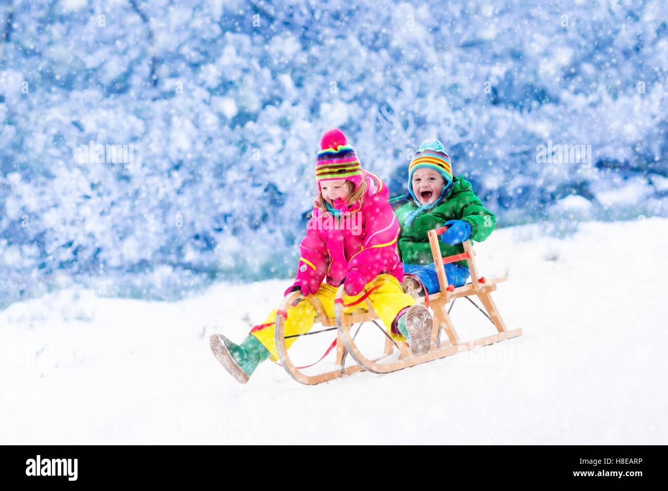 Little girl and boy enjoy a sleigh ride. Child sledding. Toddler kid ...