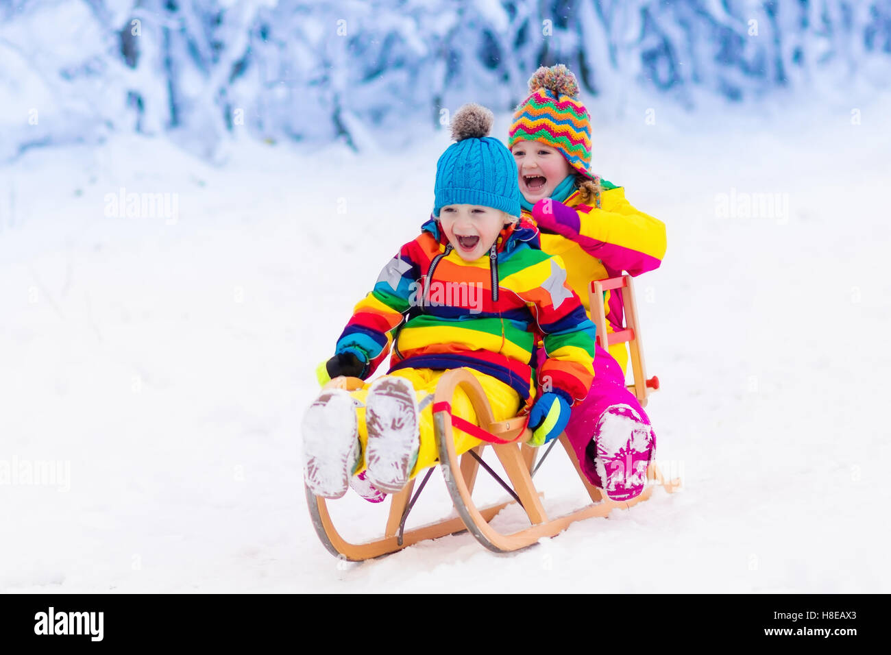 Little girl and boy enjoying sleigh ride. Child sledding. Toddler kid ...