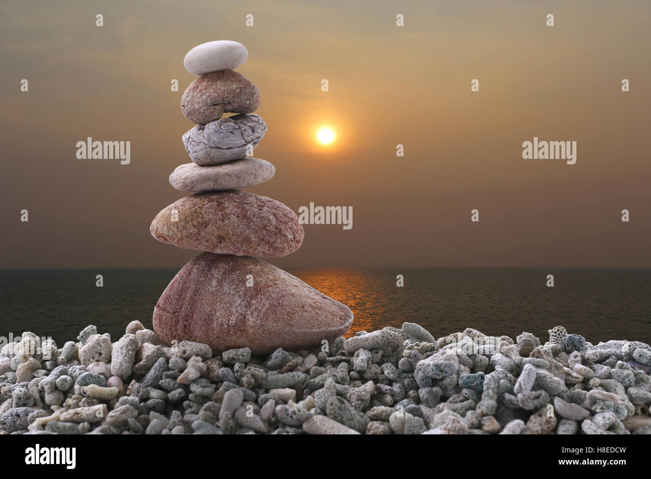 Balance stone on pile rock with sunset sea background for concept of ...