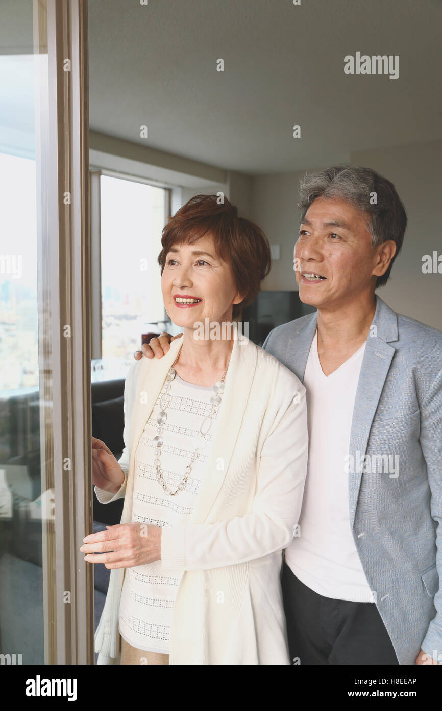 Fashionable Japanese senior couple by the window Stock Photo - Alamy