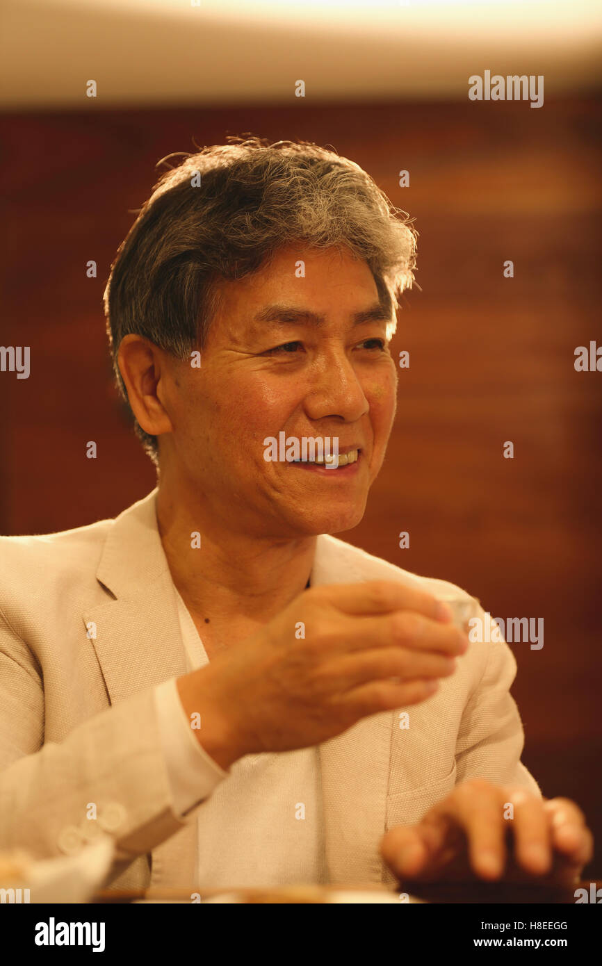 Fashionable Japanese senior man drinking sake Stock Photo - Alamy