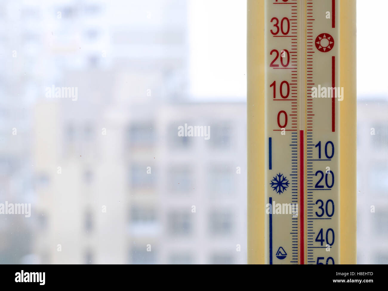 A thermometer, fixed out of the window, shows that it is zero degree ...