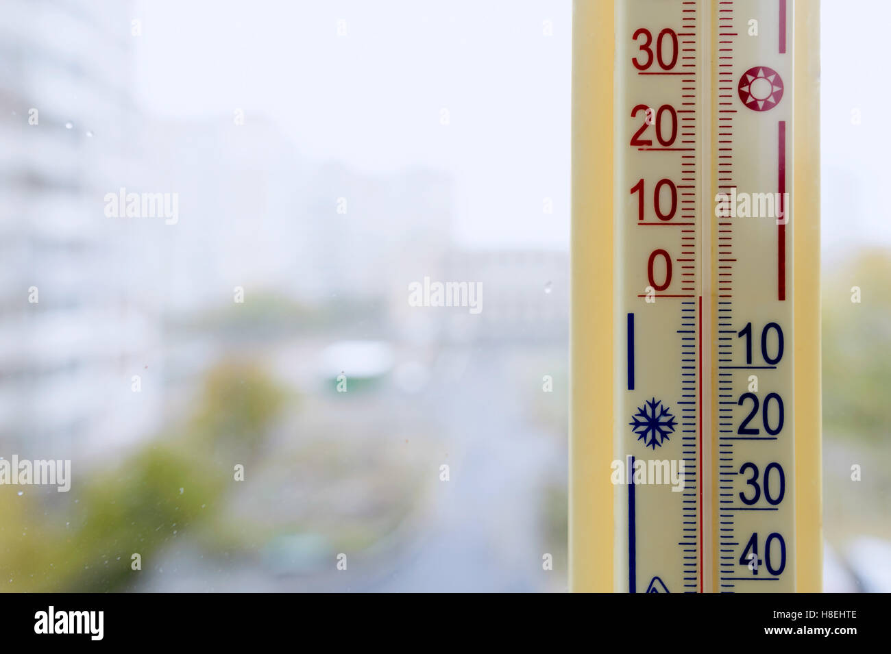 A thermometer, fixed out of the window, shows that it is zero degree ...