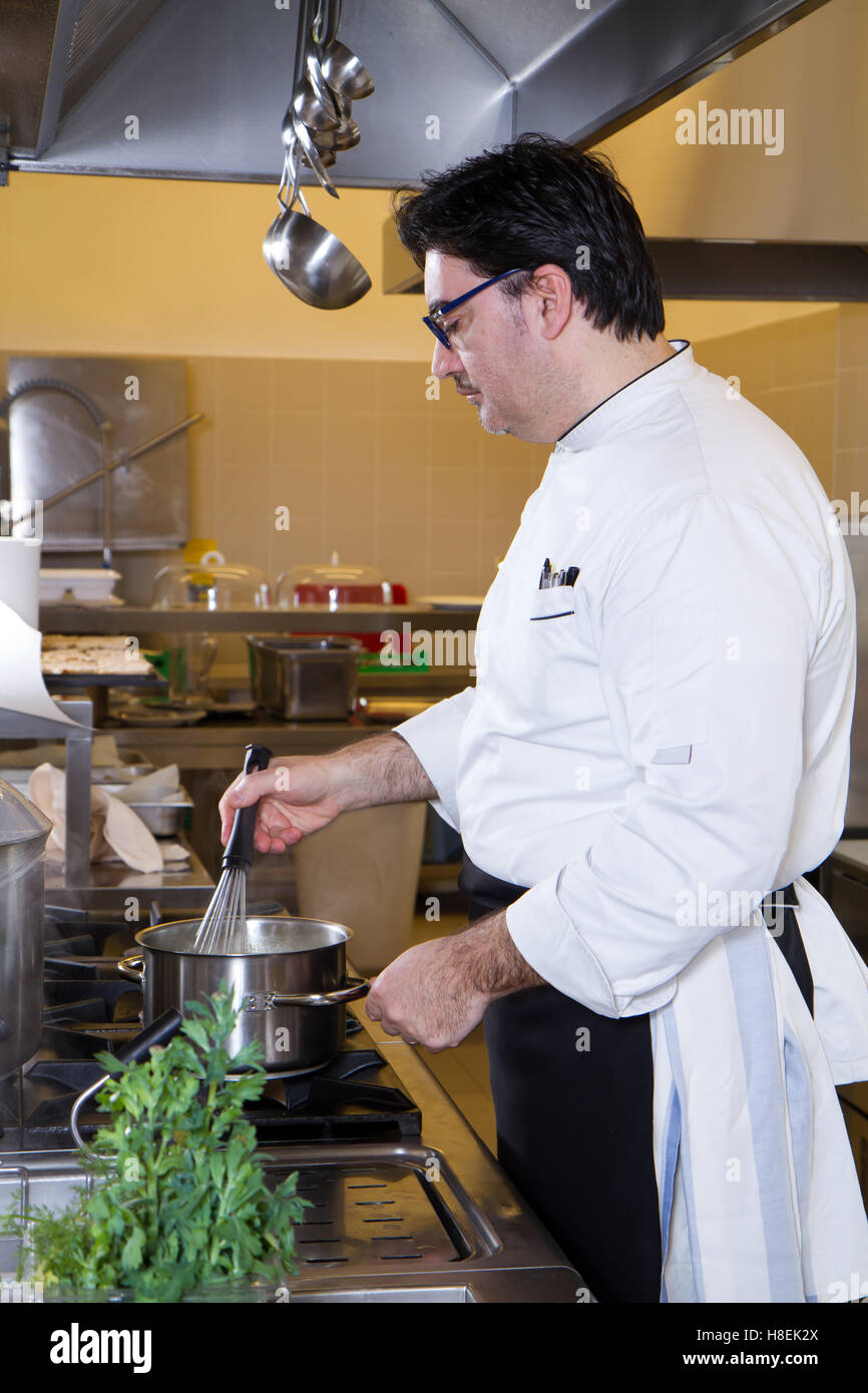 cook working in a kitchen restaurant Stock Photo - Alamy