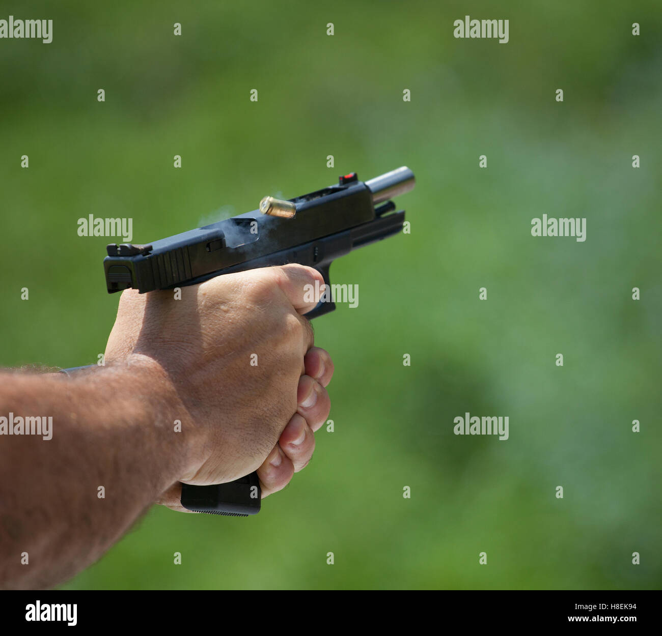 Shell flying out of the chamber of a handgun with smoke Stock Photo - Alamy