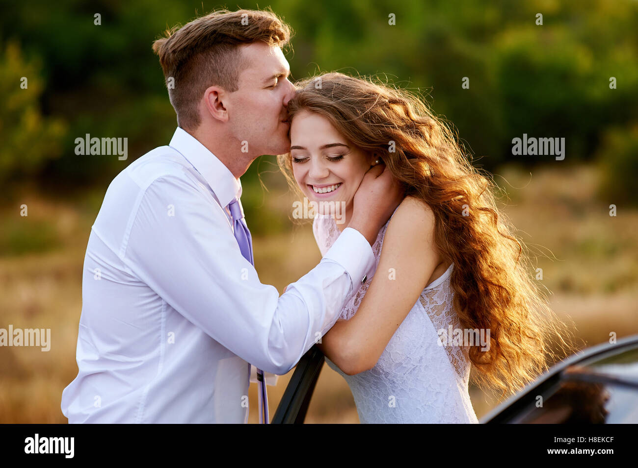 groom kissing bride in the head at the wedding walk Stock Photo - Alamy