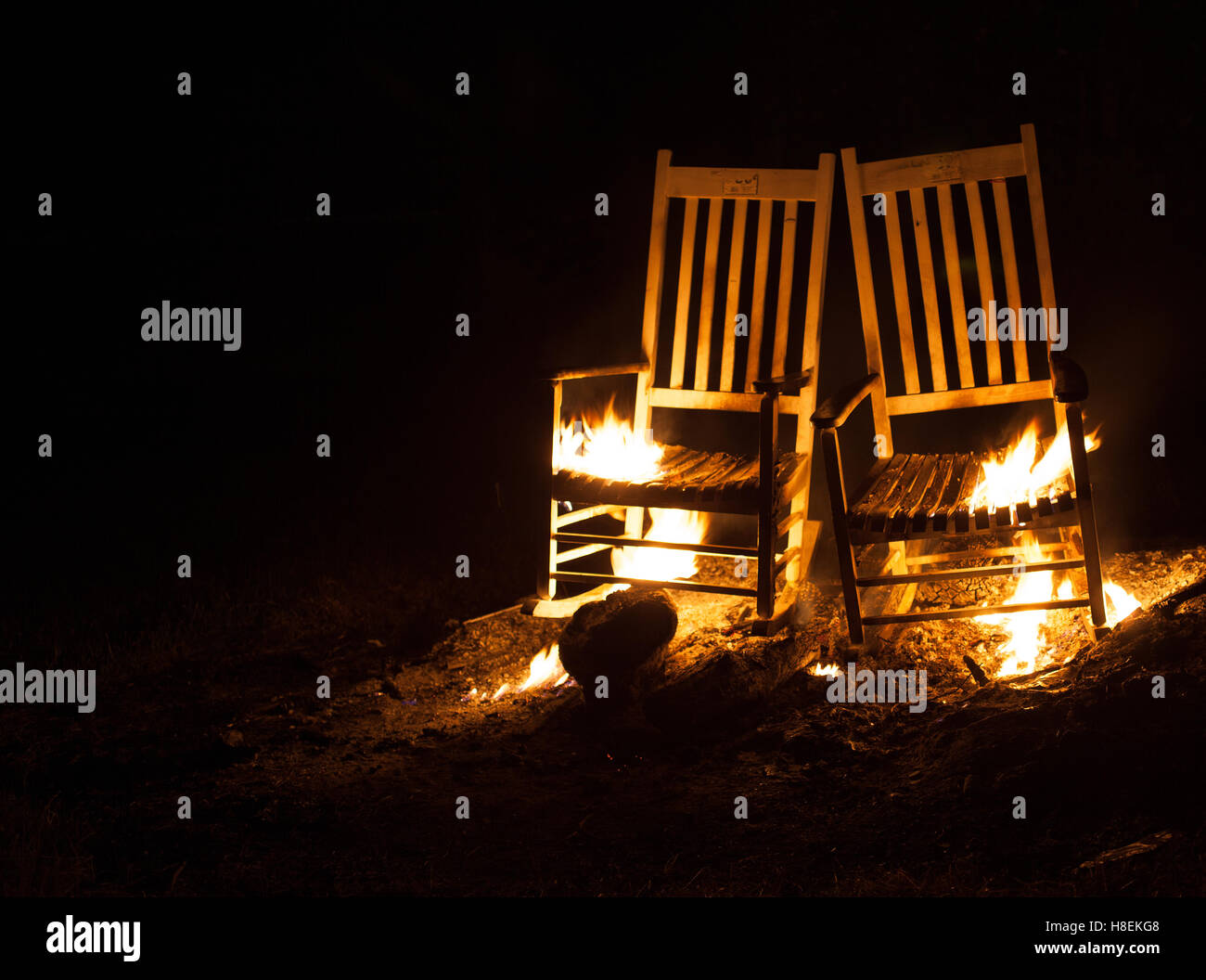 Two rocking chairs that are just beginning to burn Stock Photo - Alamy