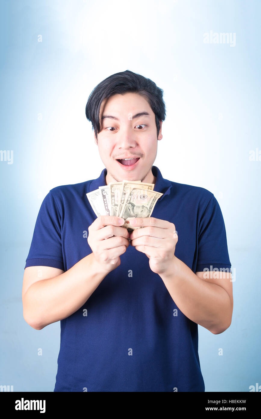 Successful Asian man. Happy young man holding money while standing and ...