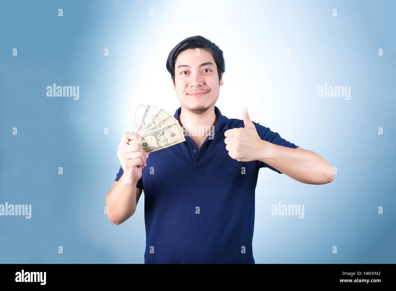 Successful Asian man. Happy young man holding money while standing and ...