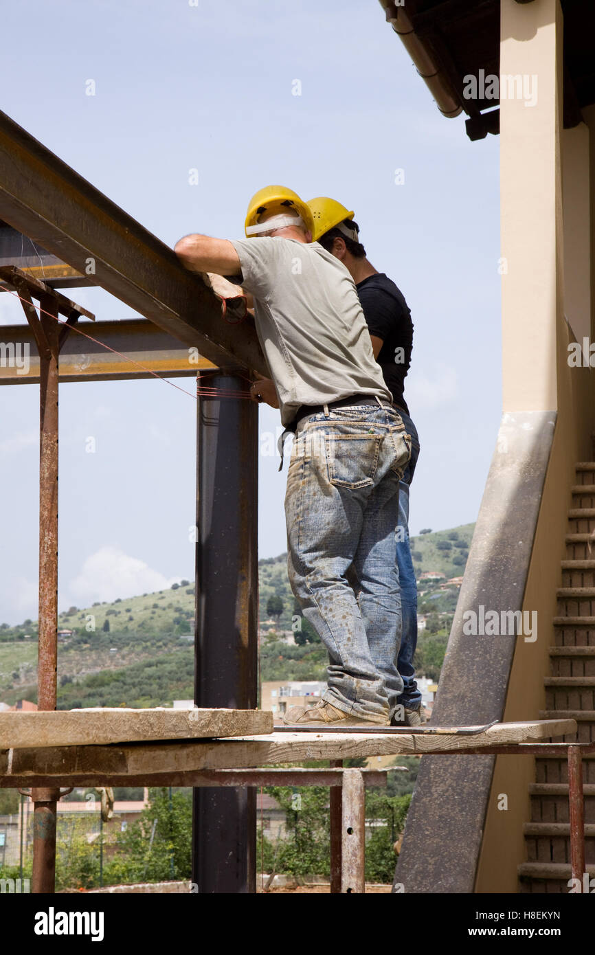 builders at work in a building site Stock Photo - Alamy