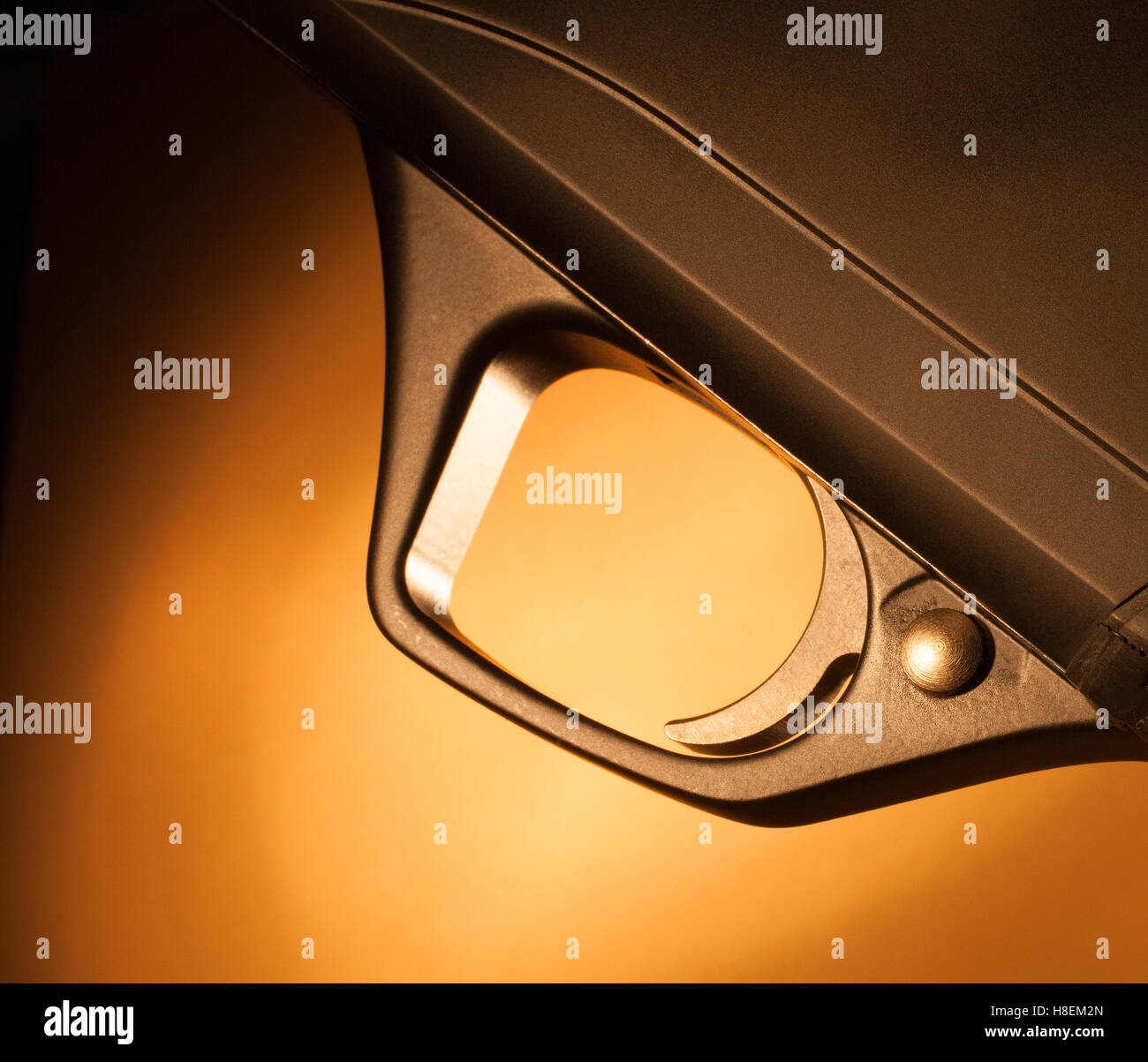 Trigger close up on a shotgun with a brown background Stock Photo - Alamy