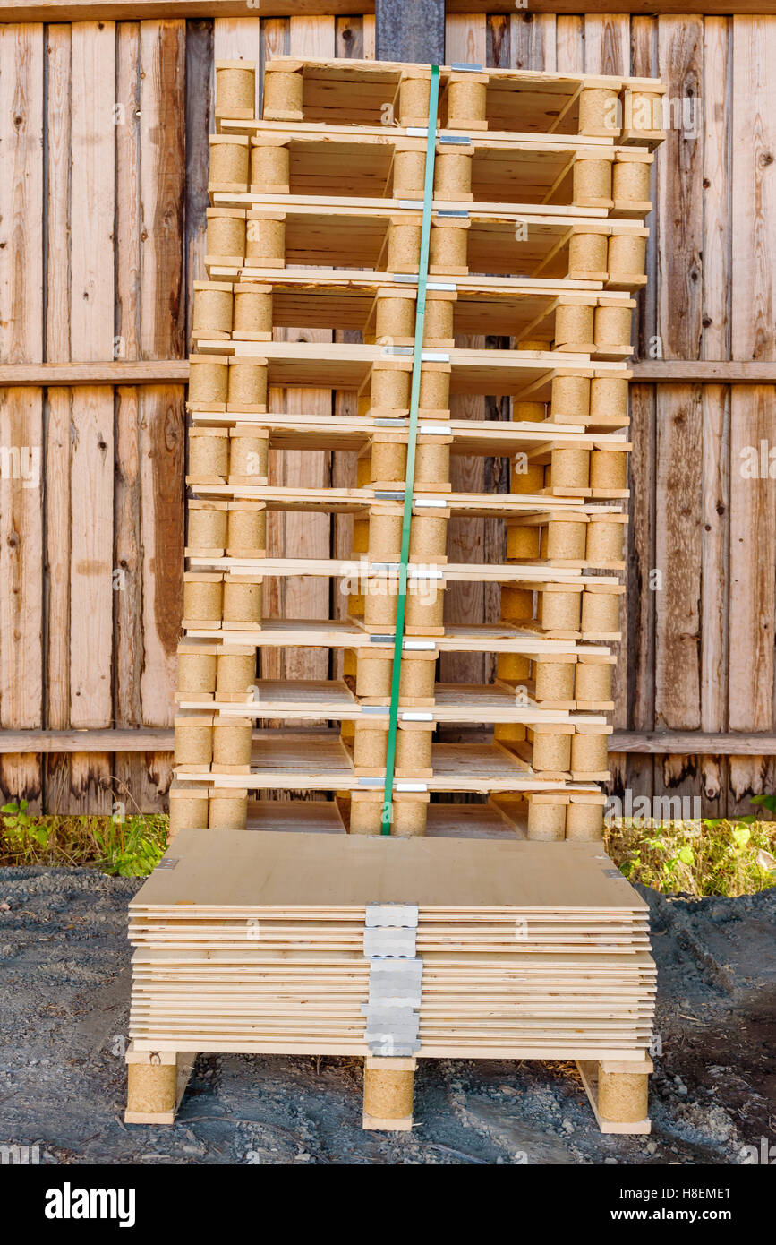 Stack of pallets and pallet material against wooden wall Stock Photo ...