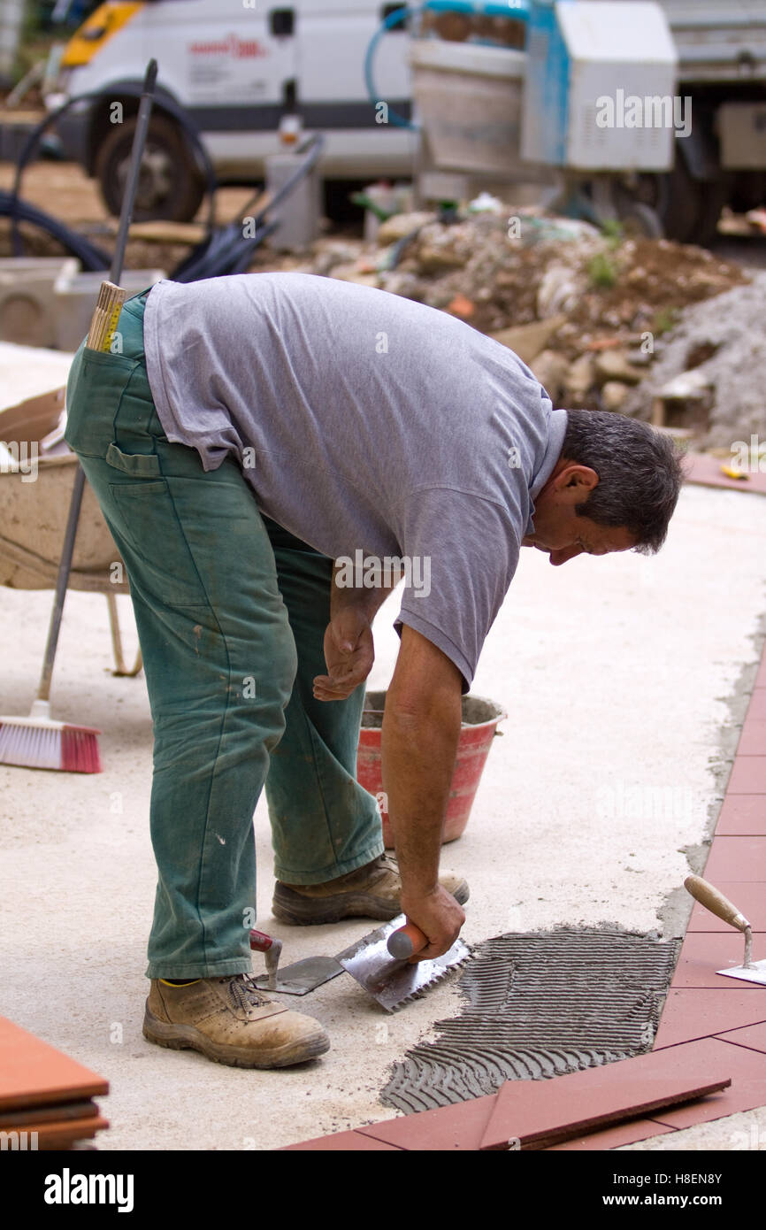 bricklayer working in a building site Stock Photo - Alamy