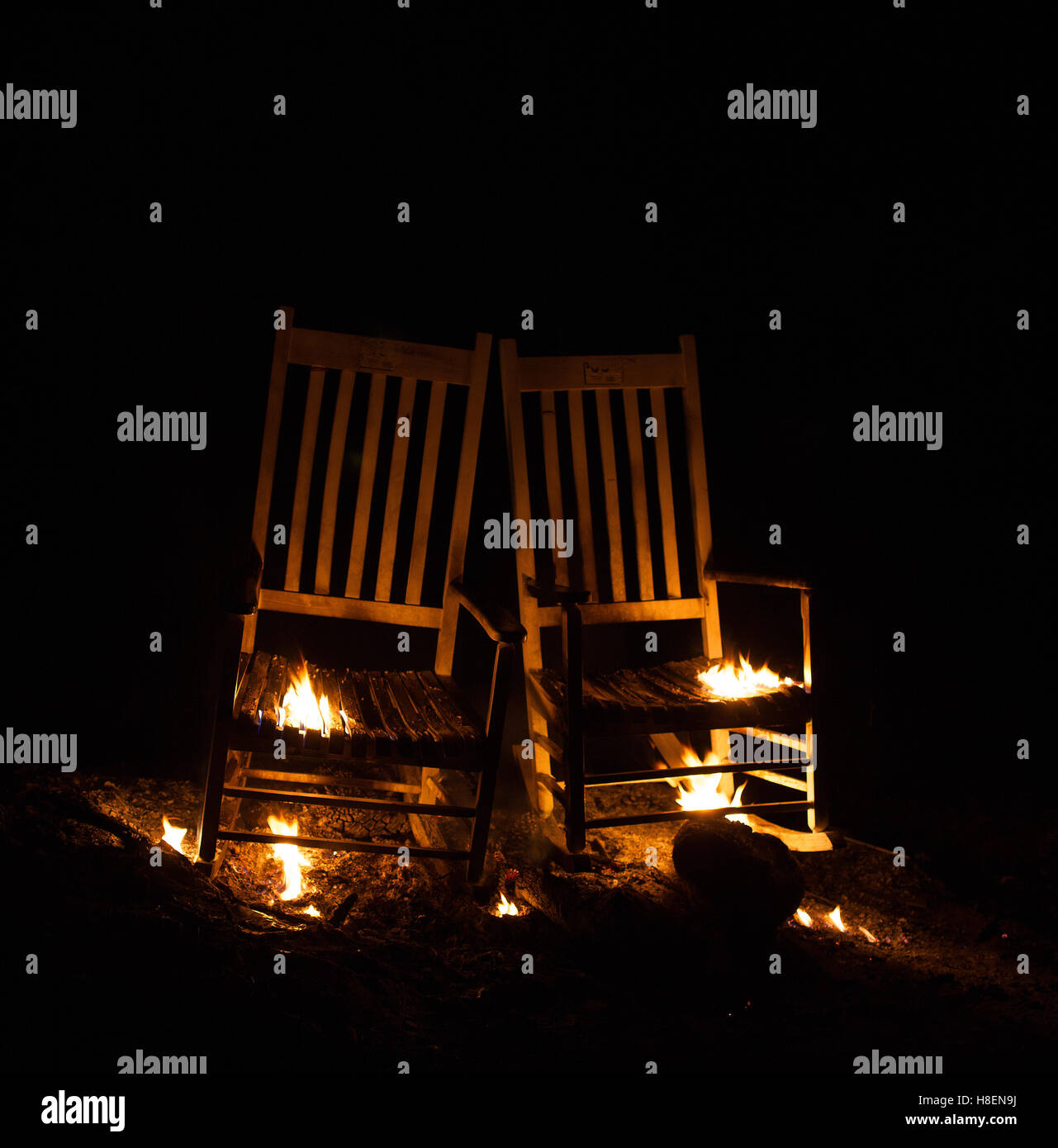 Pair of rocking chairs that are barely burning Stock Photo - Alamy