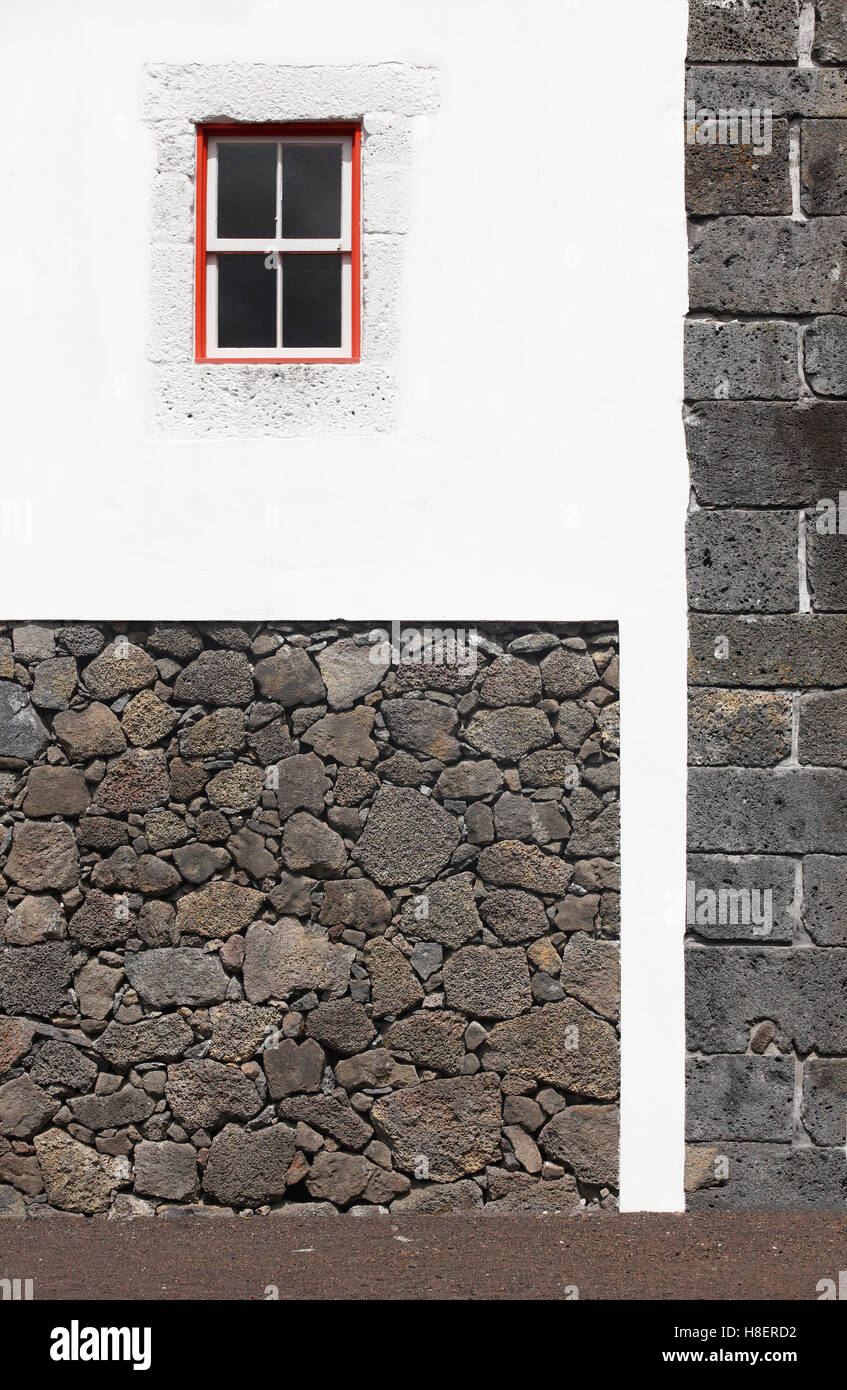 Traditional Azores building facade with volcanic rocks and white wall ...