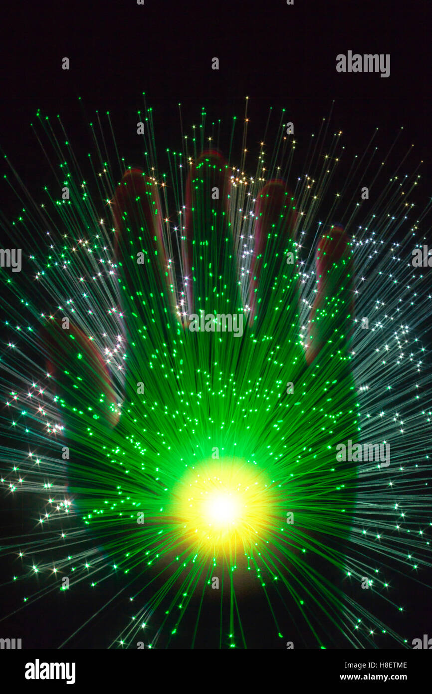 SILHOUETTE OF HUMAN HAND OVER LIT TIPS OF FIBER OPTIC STRANDS (©KECK ...