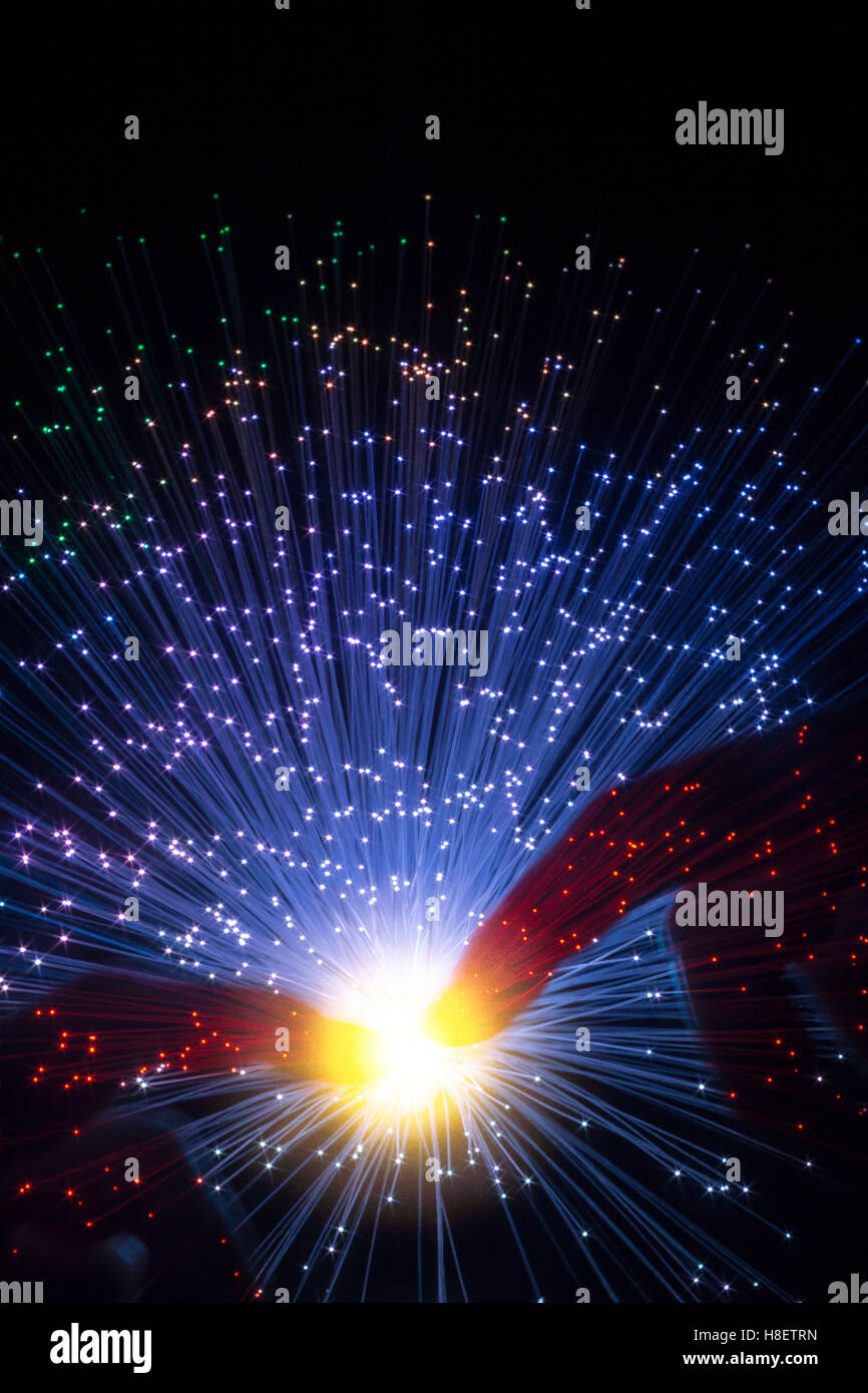 SILHOUETTES OF HUMAN FINGERS OVER LIT TIPS OF FIBER OPTIC STRANDS ...