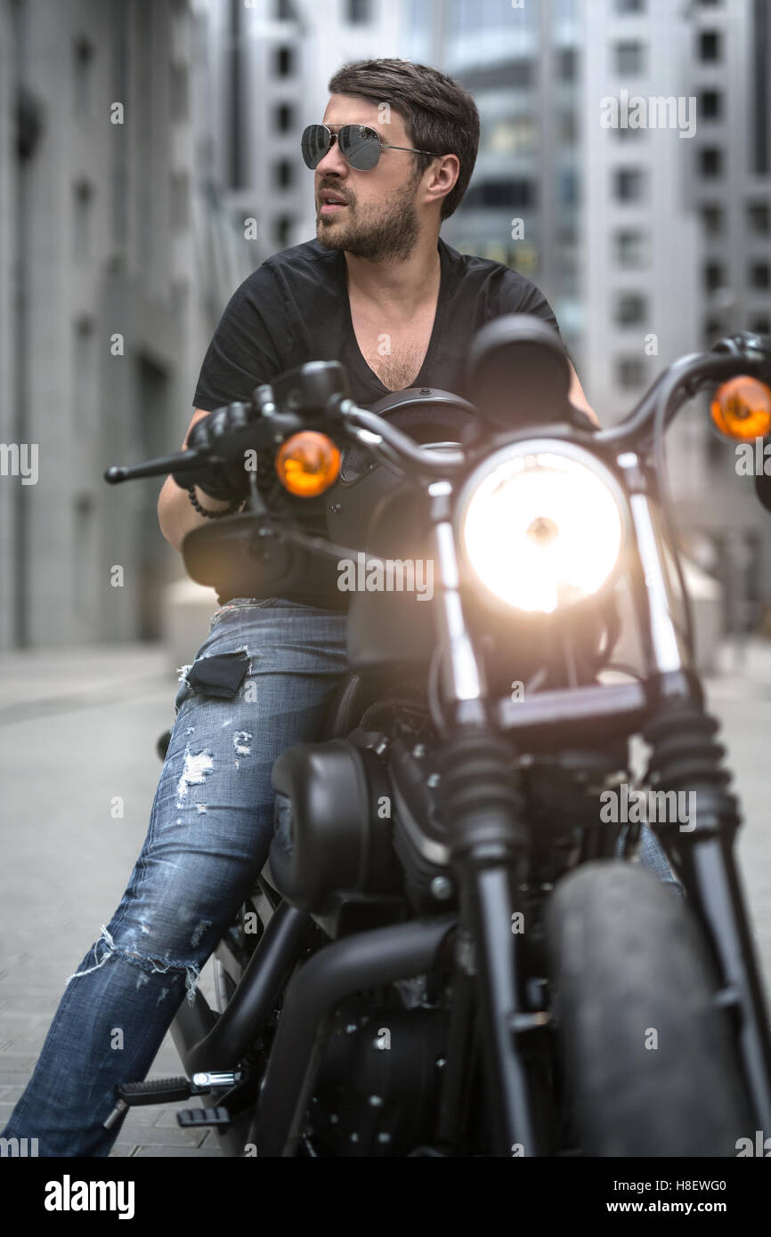 Trendy motorcyclist near skyscraper Stock Photo - Alamy