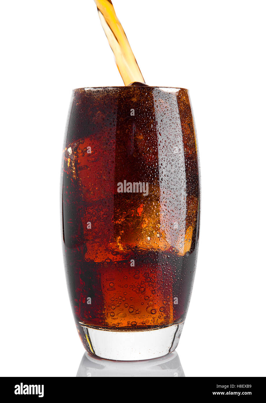 Pouring cola soda drink into the glass with ice on white background ...