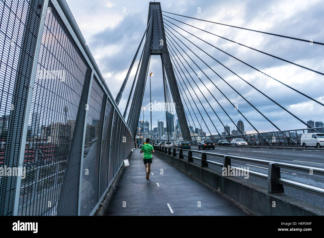 A lone runner crosses the Anzac Bridge in Sydney on an early-morning ...
