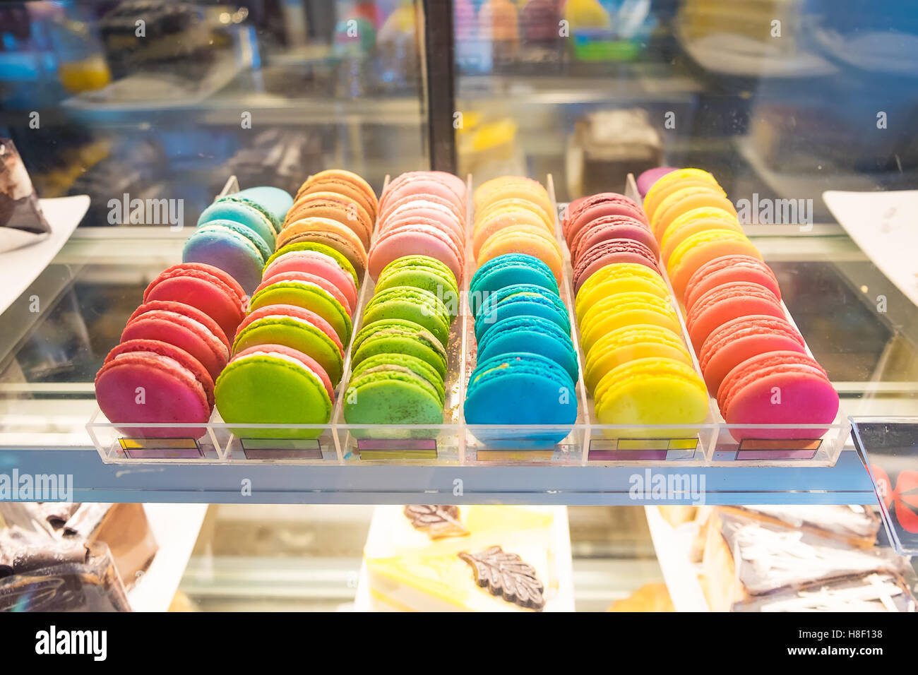 French macarons for sale on glass showcase in coffee shop, Shallow DOF ...