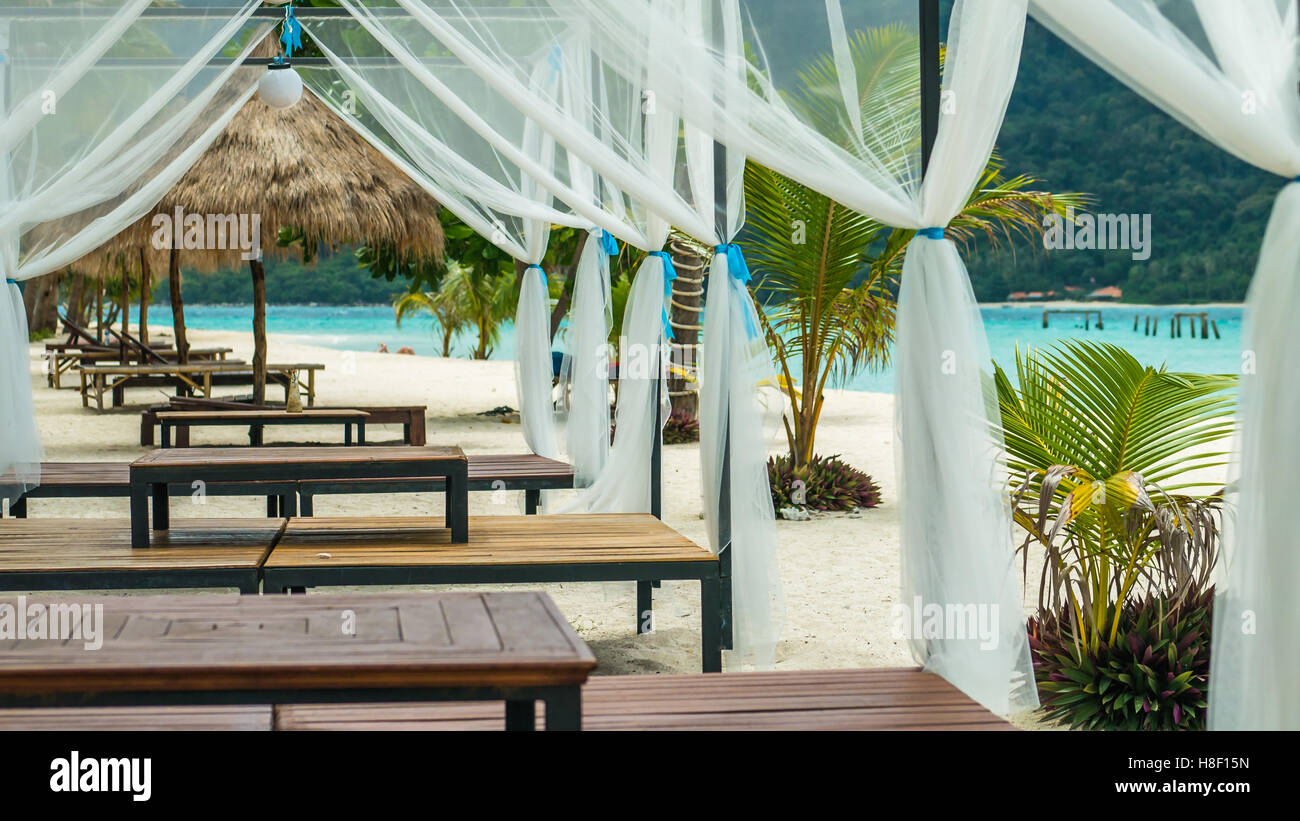 Beach bed on white sand among palm trees in full sun Stock Photo - Alamy
