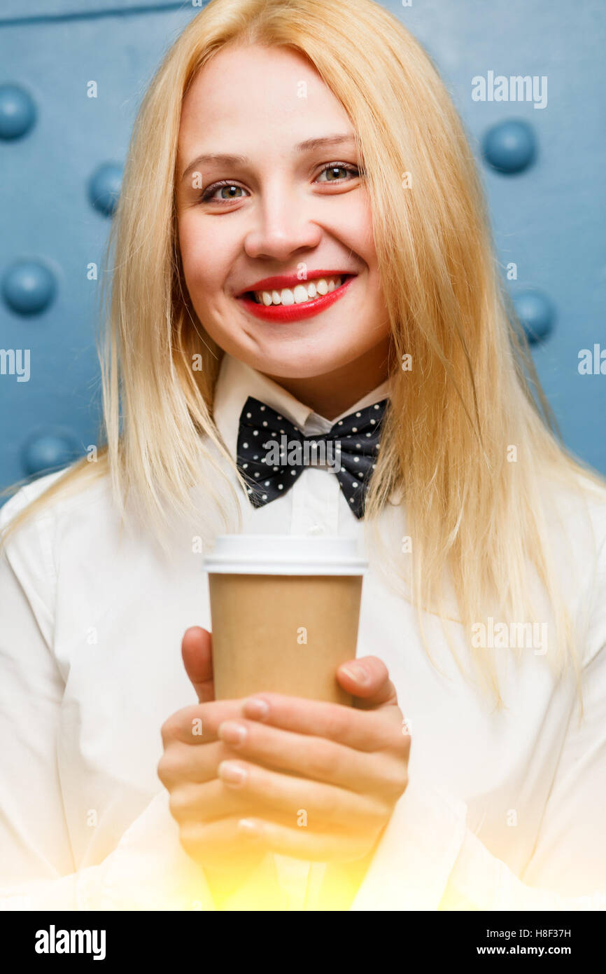 Portrait ginger laughing girl in white shirt on background blue wall ...