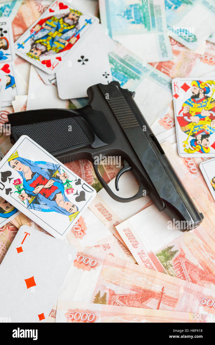 Black gun lying on the big Russian money and playing cards Stock Photo ...