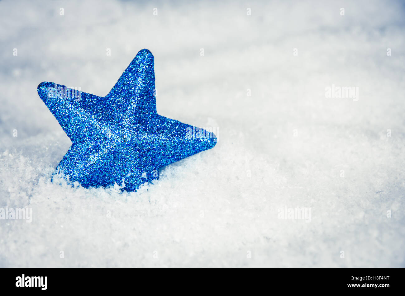 shining blue star decoration in white snow Stock Photo - Alamy