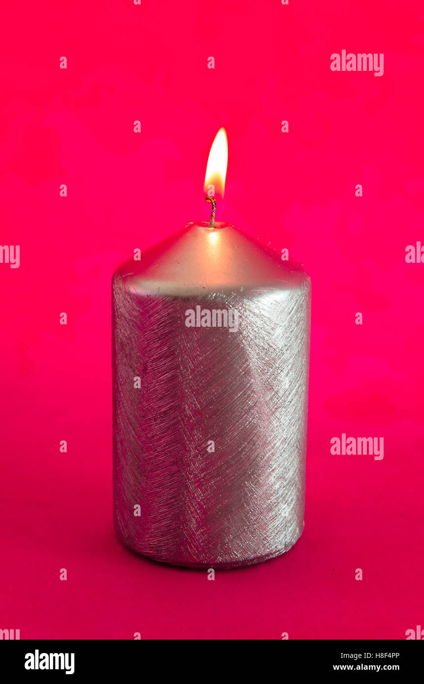 silver burning candle with vivid pink background Stock Photo - Alamy