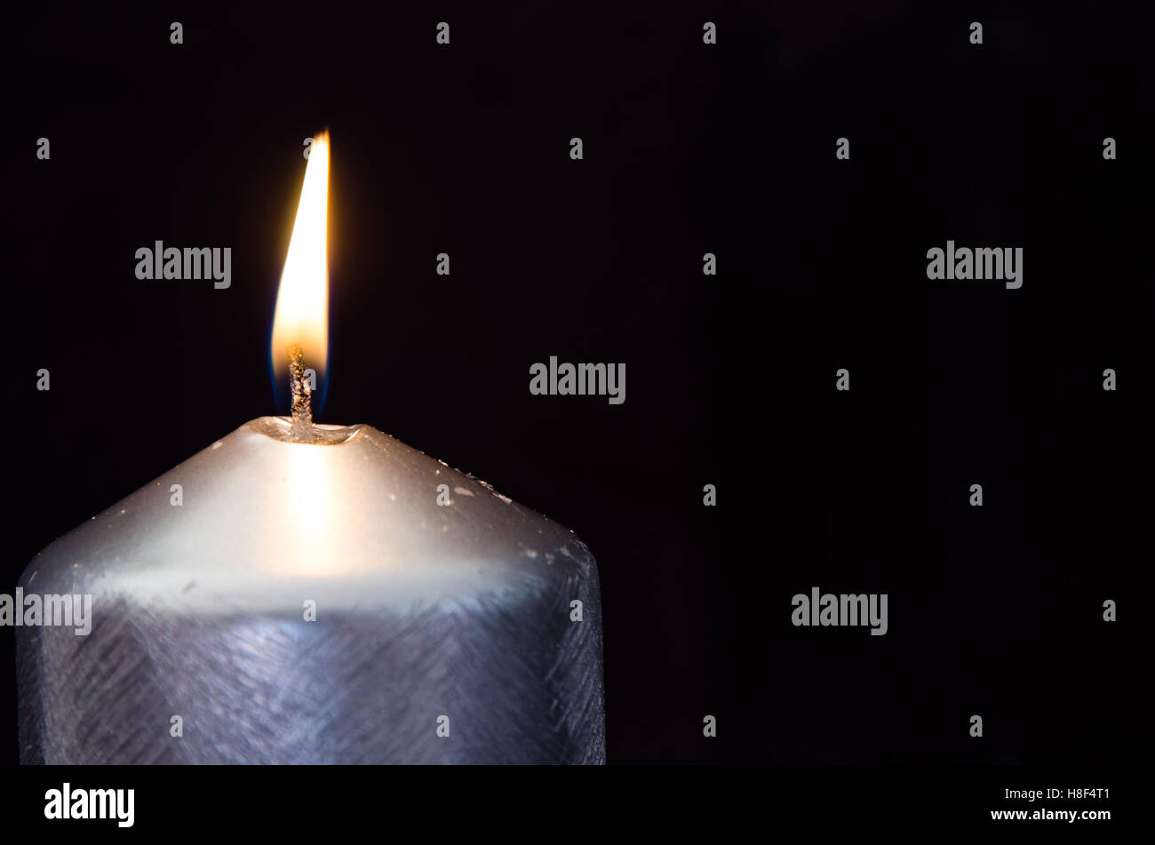 one festive silver burning candle with black background Stock Photo - Alamy