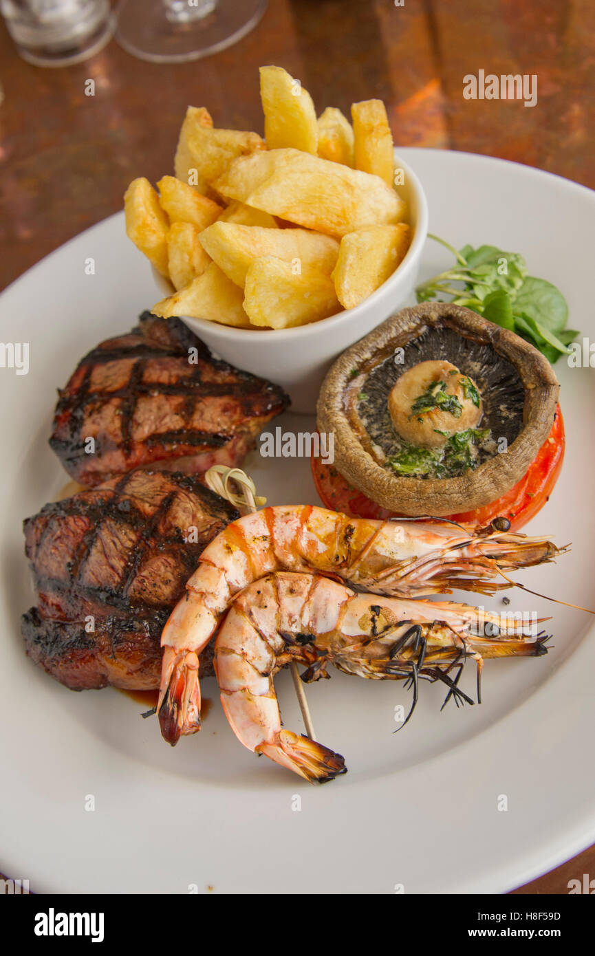 Surf & turf, steak served with prawns, chips and mushrooms. a UK food ...