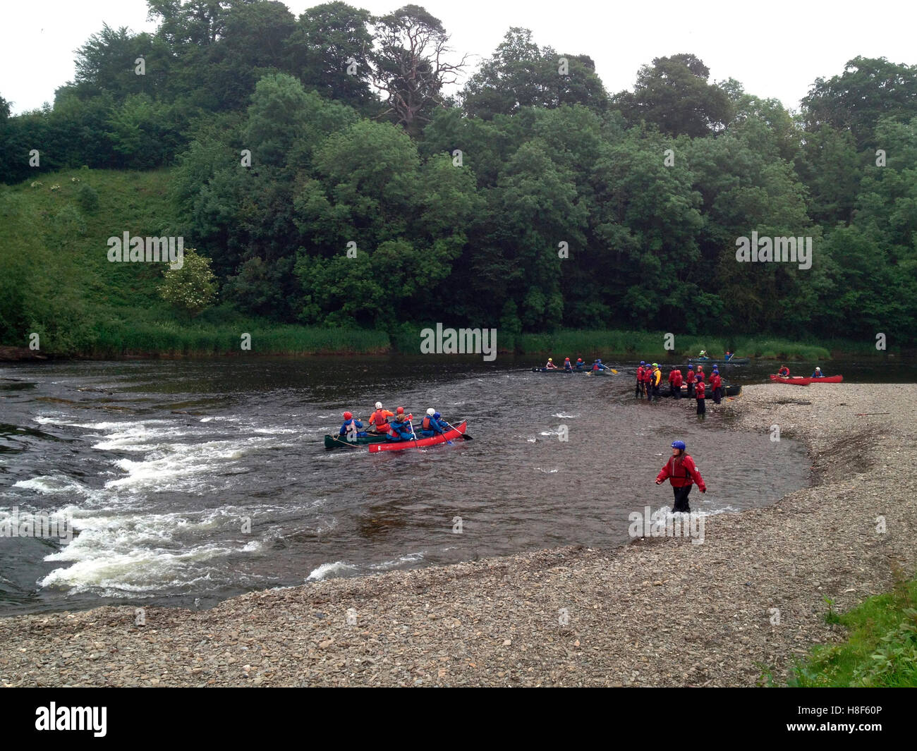 Group of teenagers canoeing on River Wye at The Warren Hay-on-Wye Powys ...
