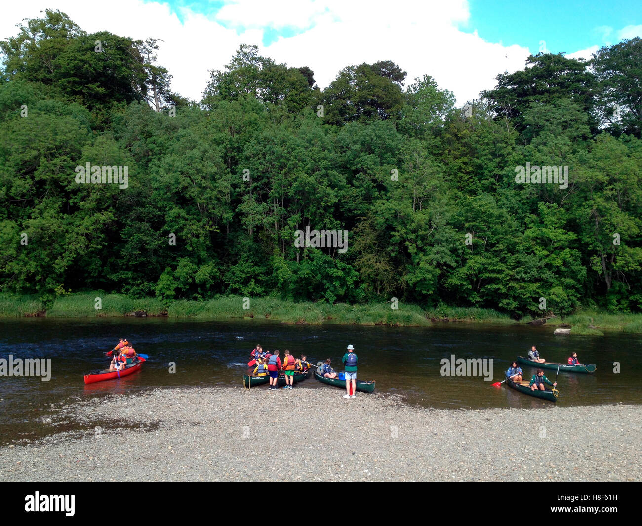 Group of teenagers canoeing on River Wye at The Warren Hay-on-Wye Powys ...