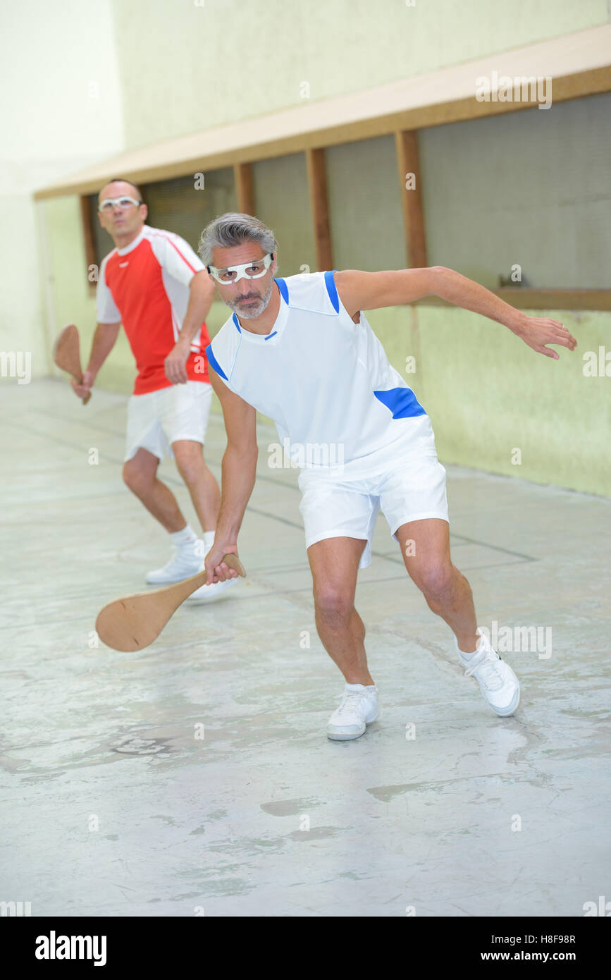 Men playing sport with wooden rackets Stock Photo - Alamy