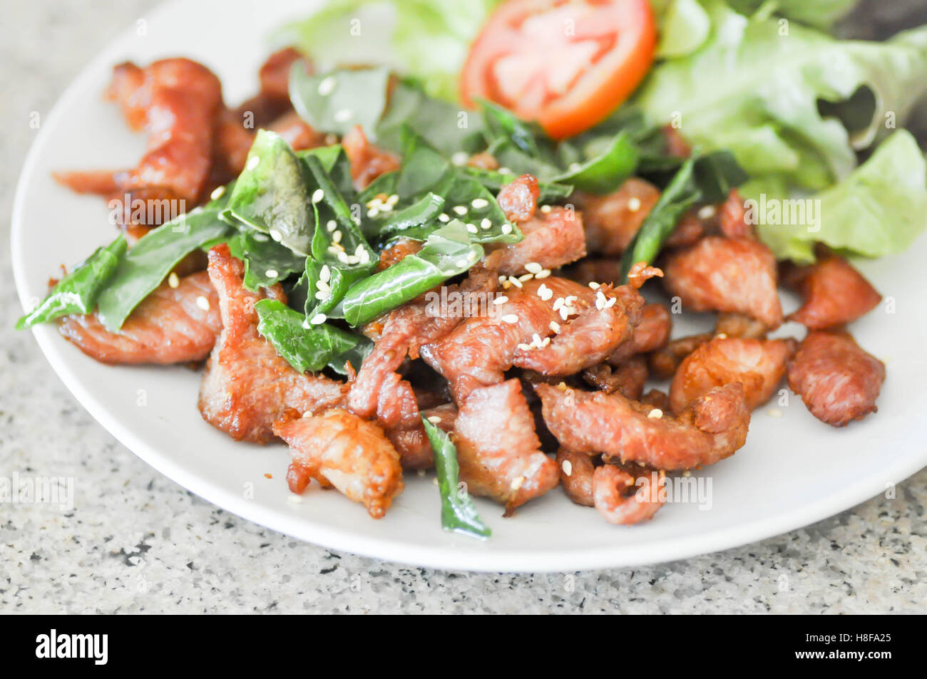 fried pok with sesame and leech lime leaf dish Stock Photo - Alamy