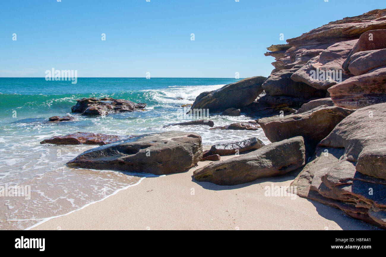 Remote beach at Pot Alley with red sandstone rock and the Indian Ocean ...