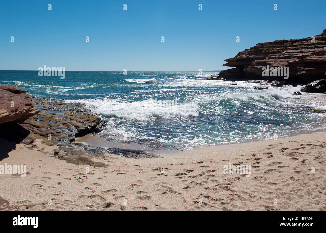 Remote beach at Pot Alley with red sandstone rock and the Indian Ocean ...