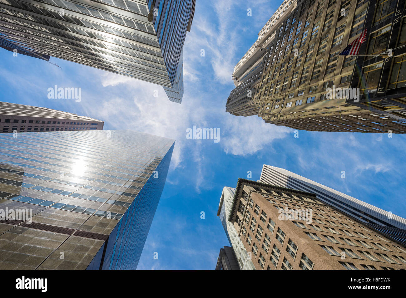 Abstract city skyline view from below looking up to blue sky between an ...