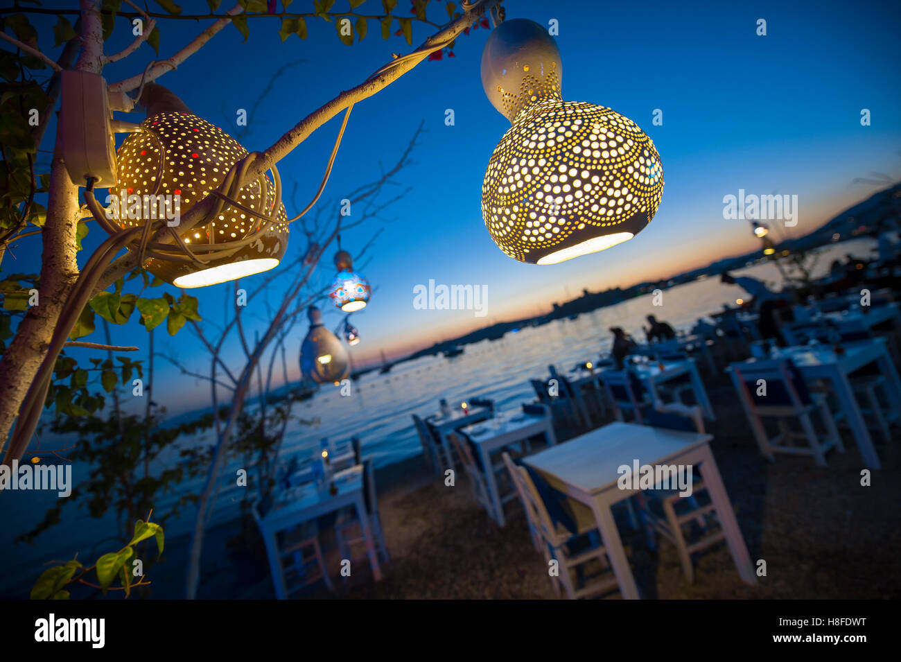 Informal beachside seating with decorative gourd lights hanging from a ...