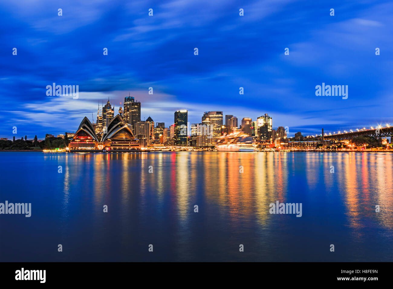 Sydney city CBD across Harbour blurred waters at sunrise when bright ...